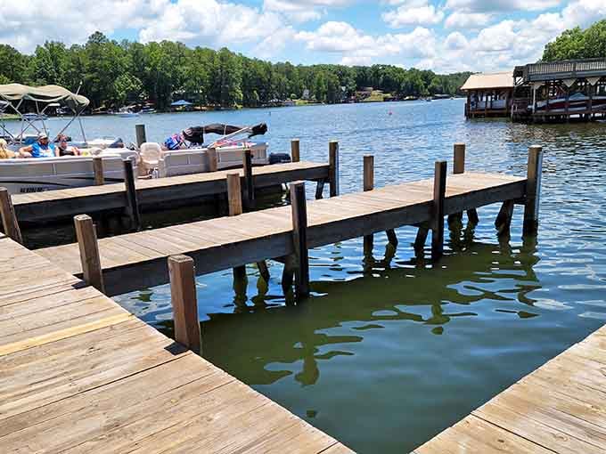 Wooden docks stretch into calm lake water where pontoon boats wait patiently for their next lazy adventure.