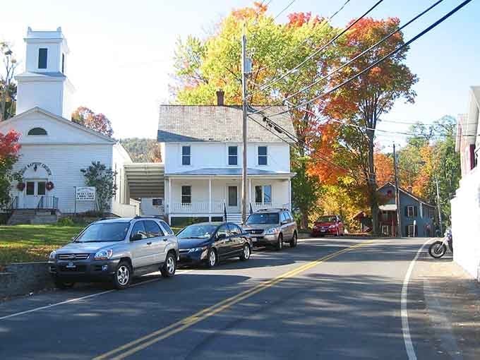 White church steeples and autumn foliage frame a quiet street where Norman Rockwell would feel right at home.