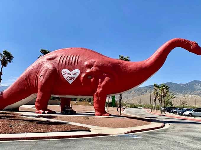 This pink dinosaur wears a heart on its side, inviting travelers to stop and smile at roadside Americana.