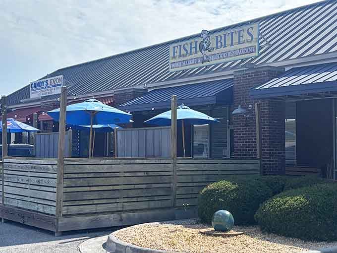 The covered patio with blue umbrellas offers shaded comfort while you enjoy your meal on a warm Southern afternoon.