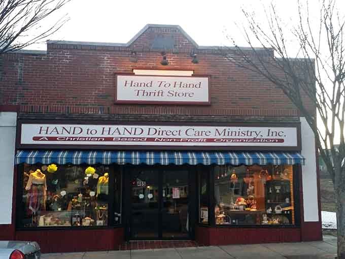 The cheerful brick facade and blue-checked awning create small-town charm that makes thrifting feel like supporting your neighbors.