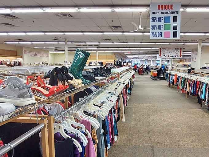 Color-coded discount signs hanging overhead promise savings that increase daily like compound interest for your closet's future.