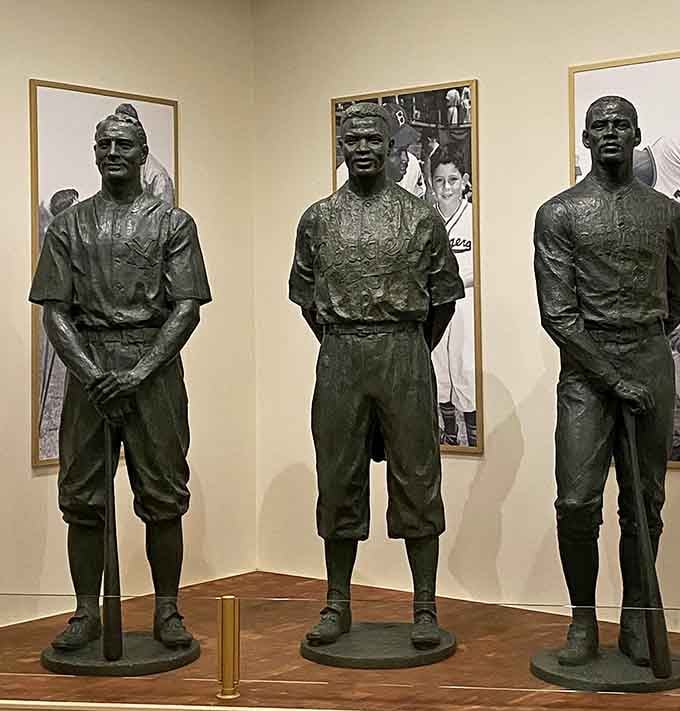 Bronze statues honor baseball legends standing together in timeless tribute to America's beloved national pastime.