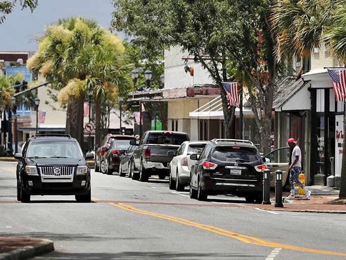 Palm trees sway above a main street where the American flag flies and people still pause to appreciate it.