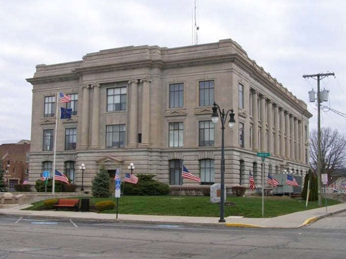 Patriotic flags flutter near the building steps, celebrating the freedom to live well without going broke trying.