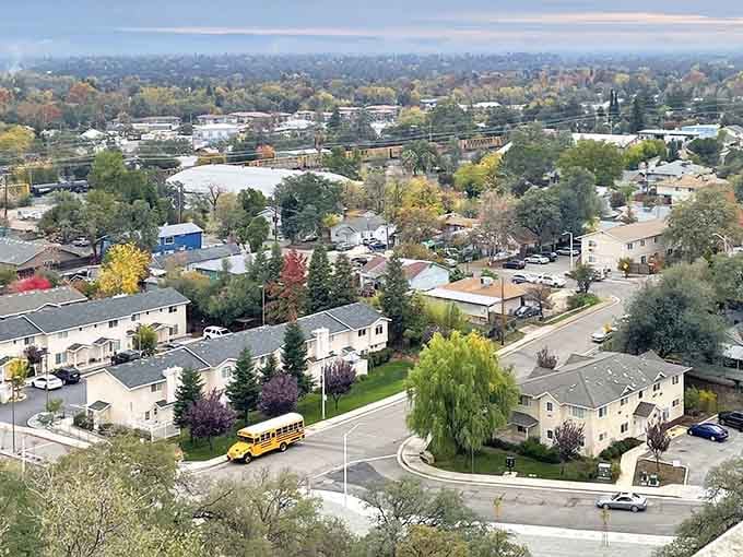 Autumn colors paint the residential streets while a yellow school bus adds a Norman Rockwell touch.