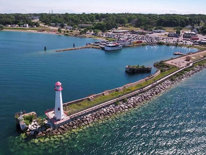 From this bird's-eye view, the lighthouse looks like a tiny sentinel protecting the harbor's brilliant blue embrace.