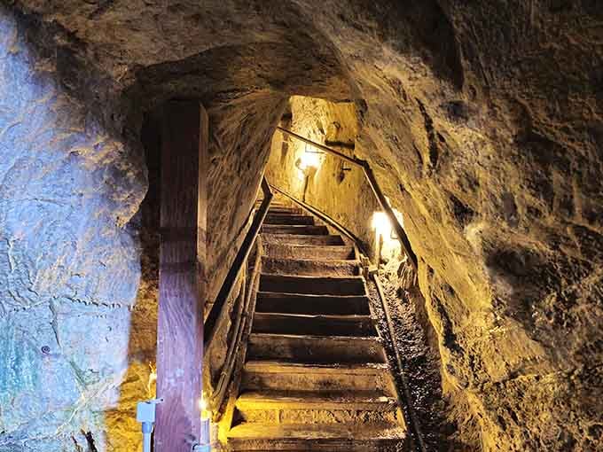 Wooden stairs lead down into the illuminated passage, where every step takes you deeper into geological history itself.