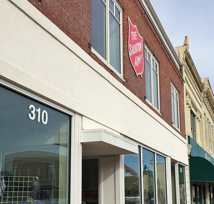 The Salvation Army's iconic shield watches over downtown Manhattan, Kansas, promising treasures with purpose inside.