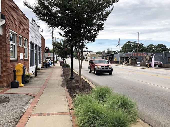 Brick sidewalks and mature trees create a main street where every storefront feels like a neighbor welcoming you home.