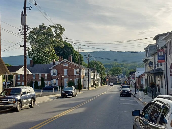 Mountains frame the distant horizon while everyday life unfolds on streets that have witnessed generations of neighbors passing.