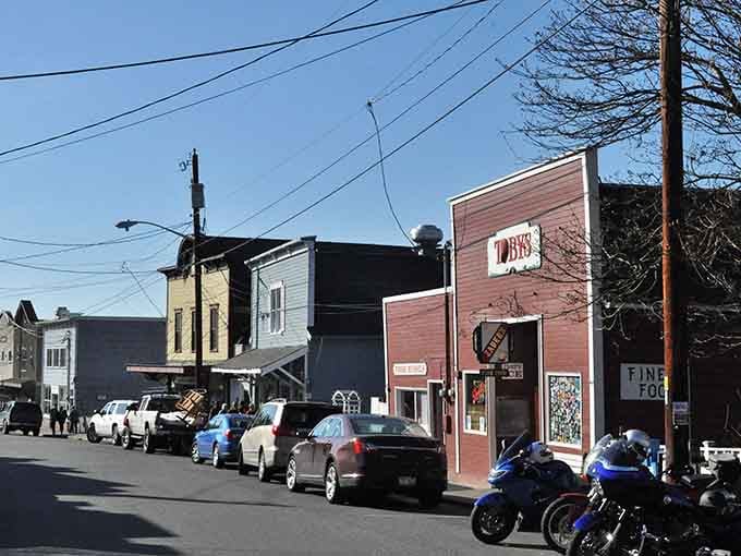 Mismatched storefronts create an authentic main street where character trumps uniformity and every building tells its own story.