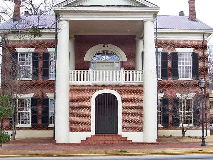 That Federal-style portico and fanlight window showcase craftsmanship from an era when buildings were built to impress forever.