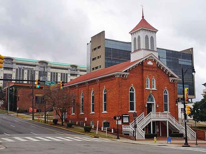 Historic brick church stands firm against modern glass, proving old and new can be excellent neighbors.