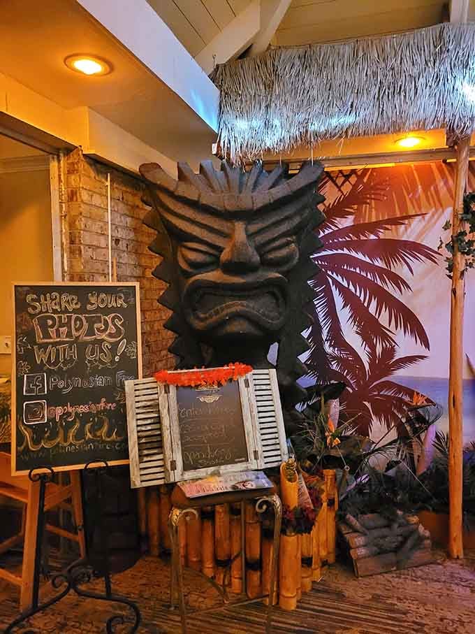 That towering tiki statue surrounded by bamboo and tropical vibes promises an authentic Polynesian feast and fire dancing spectacle.