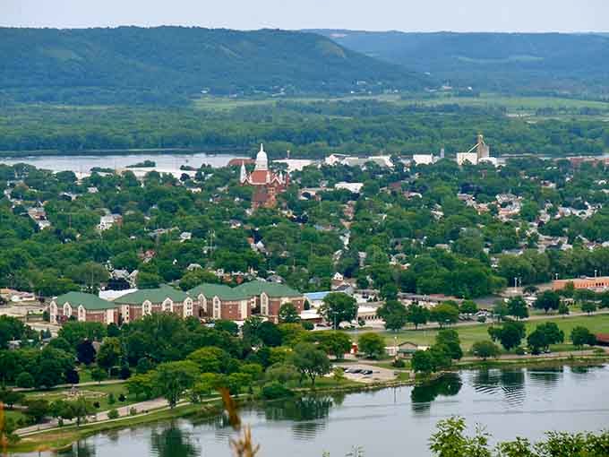 Church steeples punctuate the tree-covered landscape, marking this riverside community nestled between water and rolling hills.