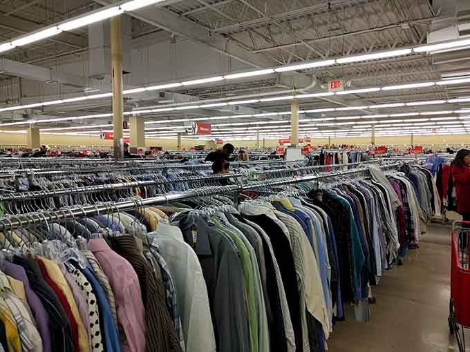 Rows of clothing stretch endlessly like a fabric rainbow, proving that one person's closet purge is your wardrobe jackpot.
