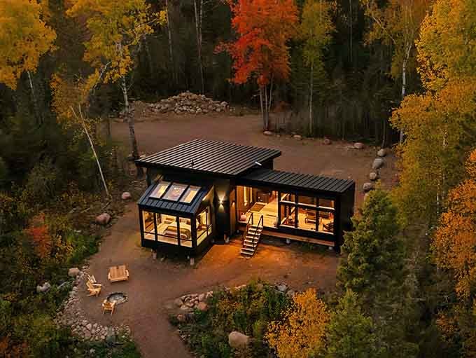 Sunset paints the sky like a cosmic artist showing off, while this modern cabin sits pretty among fall's finest work.