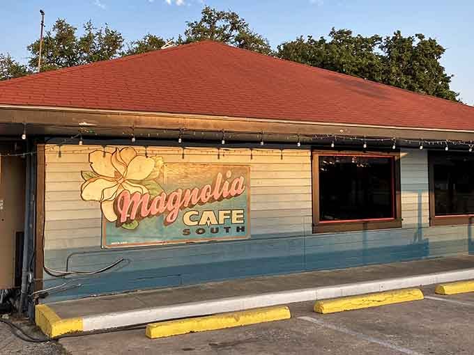 The vintage Magnolia Cafe sign glows like a promise that good food and better vibes await inside.