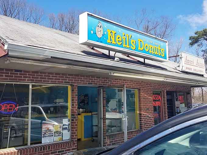 That cheerful cartoon donut on the sign knows something you don't: what awaits inside is worth waking up early for.