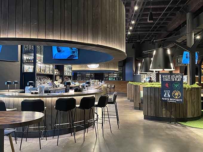 The curved bar beckons like a siren song, promising craft cocktails and front-row views of the action.