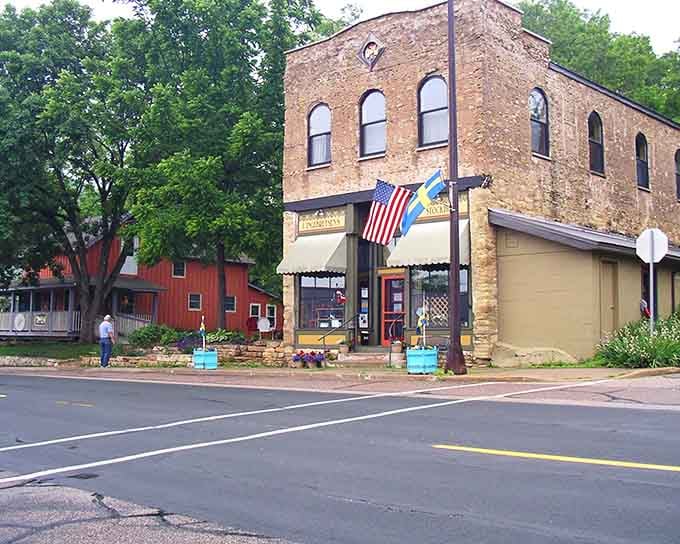 Historic brick buildings and patriotic flags create a Main Street scene that feels like stepping into a Norman Rockwell painting.