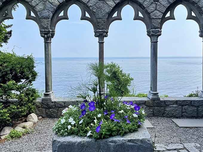 Purple blooms meet ancient stonework where the ocean becomes your personal castle backdrop every single day.