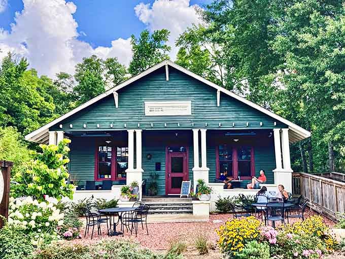 That charming green bungalow with the welcoming porch is where books meet beverages in perfect harmony.