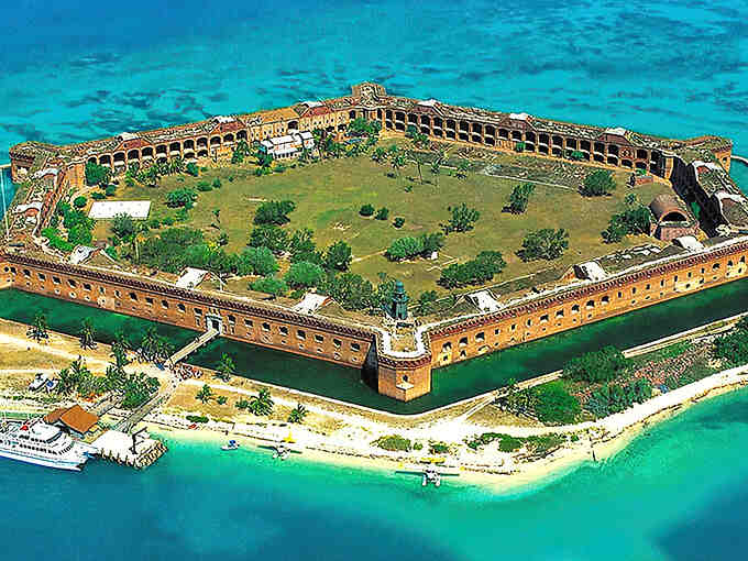 From above, this hexagonal fortress looks like someone dropped a massive brick Lego set into paradise's clearest waters.