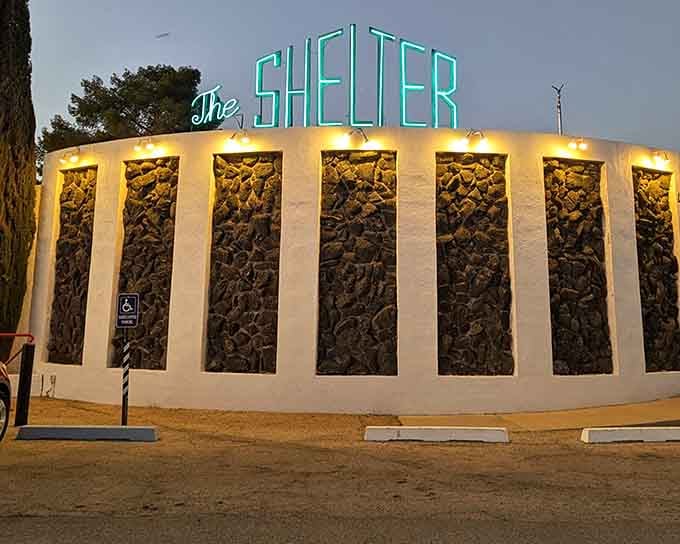 That retro-futuristic facade glows like a beacon of hope in the desert twilight, promising shelter and seriously good drinks.
