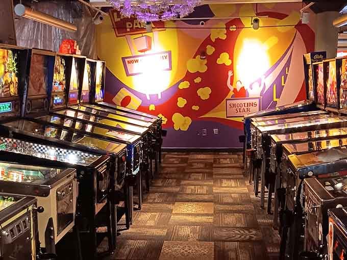 Rows of vintage pinball machines stand ready like soldiers of nostalgia, waiting to devour your afternoon with pure joy.