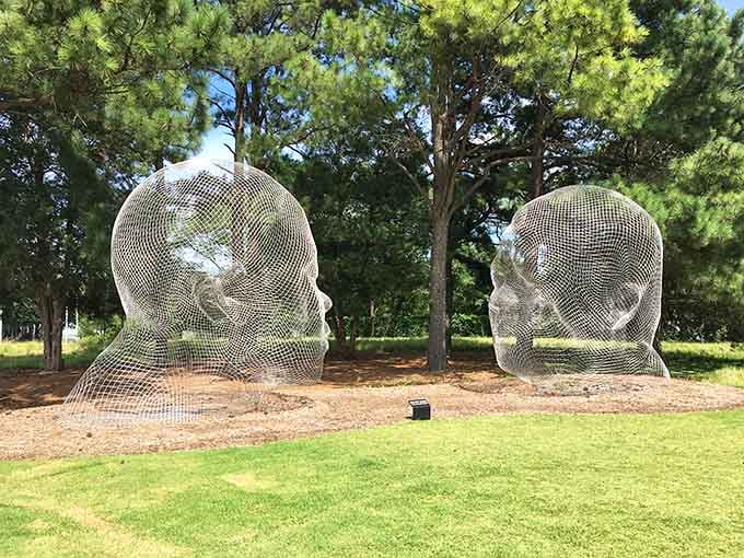 Giant wire-mesh heads sitting in a field, because North Carolina does monumental art with serious style and whimsy.
