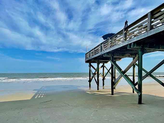 That fishing pier stands like a wooden sentinel, inviting you to cast a line into Atlantic dreams.