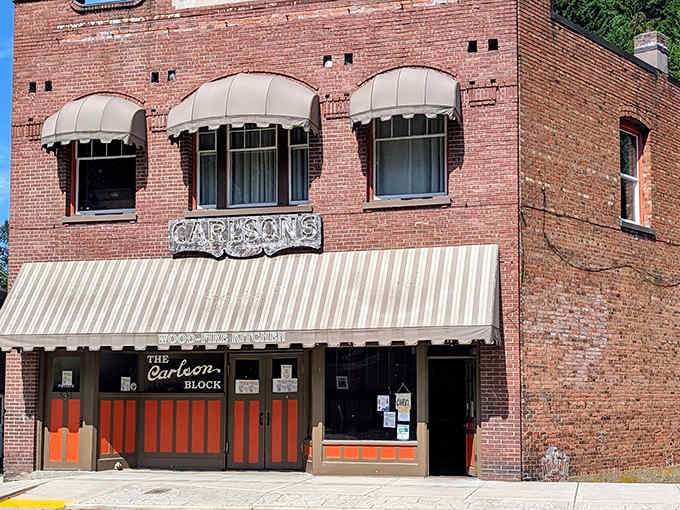 Those bright orange accents against weathered brick create a vibe that's equal parts vintage charm and modern pizzeria cool.