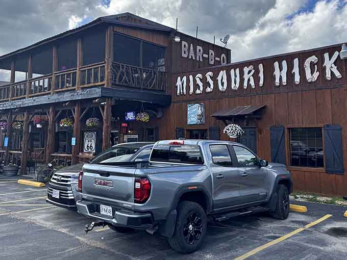 That rustic two-story facade isn't just for show, it's your first hint that serious barbecue awaits inside those wooden walls.