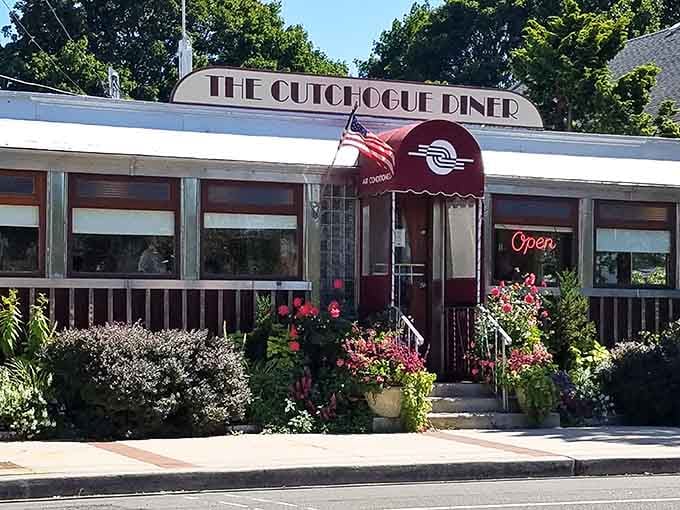 The burgundy awning and blooming garden whisper "come in, we've been expecting you" in the sweetest way.