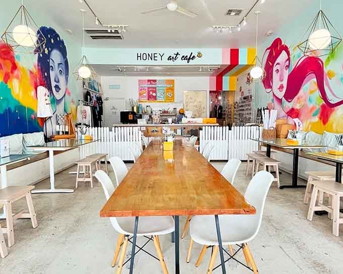 Those vibrant murals flanking the communal table transform coffee time into a gallery experience worth savoring slowly.