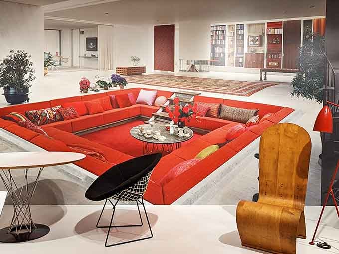 That orange conversation pit in the background looks like it swallowed the entire 1970s and refuses to give them back.