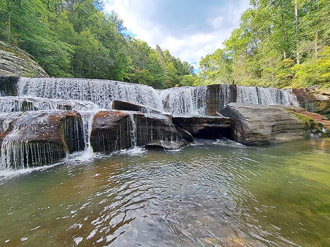 That layered waterfall spilling into an amber pool is basically nature's version of a luxury resort infinity pool.