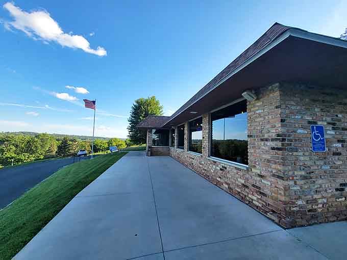 That classic brick exterior and rolling hill backdrop practically whisper "supper club" before you even step inside.