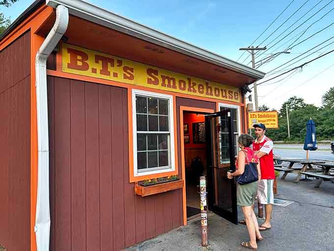 That charming rustic exterior practically whispers "serious barbecue happens here," and those eager customers heading inside know exactly what's up.