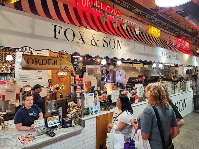 That striped awning beckons like a carnival tent, promising fried delights and zero regrets inside Reading Terminal Market.