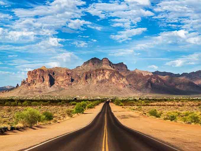 That ribbon of asphalt stretching toward those ancient peaks? That's your escape route from reality calling.