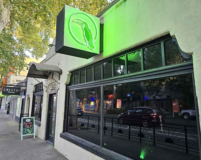 That glowing green bird sign is your beacon to paradise, calling you off Sacramento's streets into tropical bliss.