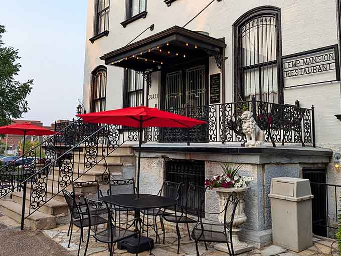 That ornate ironwork patio whispers of genteel afternoons, though the spirits inside prefer their gatherings after dark.