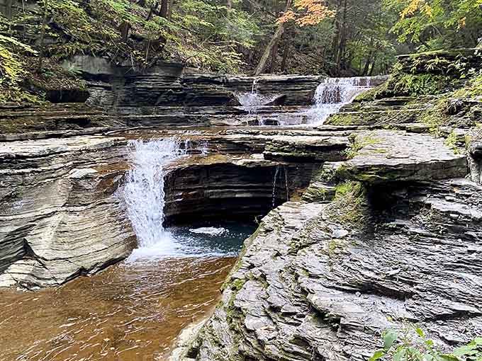 Water cascading over layered rock shelves like nature's own marble staircase, each pool more inviting than the last.
