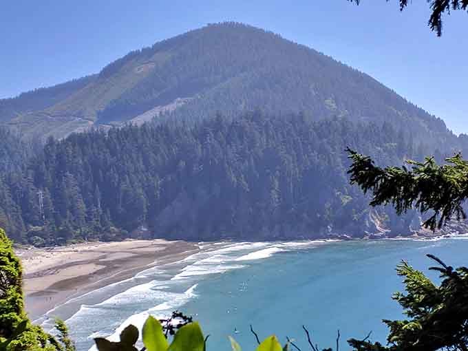 Neahkahnie Mountain rises like nature's own pyramid, guarding a beach where forest literally meets surf in spectacular fashion.