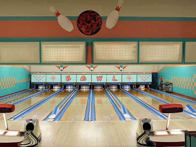 Above the pins, that whimsical bowling ball and pin artwork sets the playful tone for everything happening below.