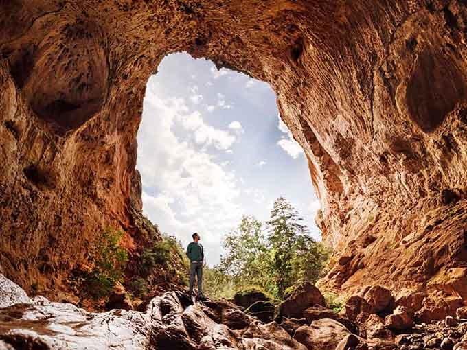 Standing beneath nature's cathedral where golden travertine walls frame the sky like a Renaissance painting come to life.