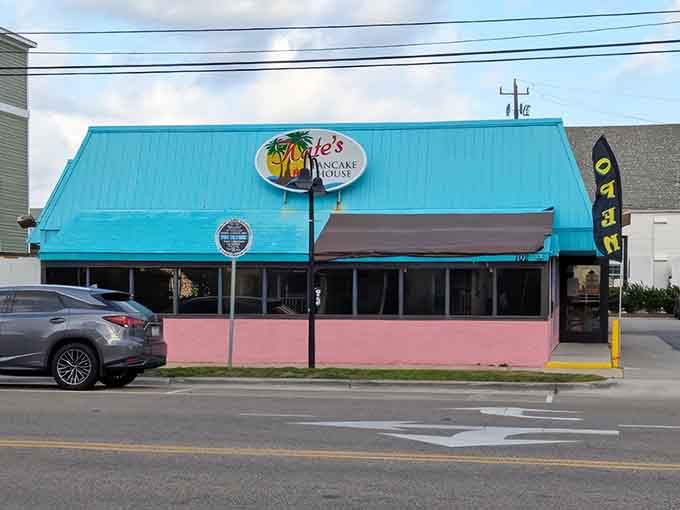 That turquoise roof and pink base aren't whispering; they're shouting "pancakes here!" loud enough to wake the whole beach.